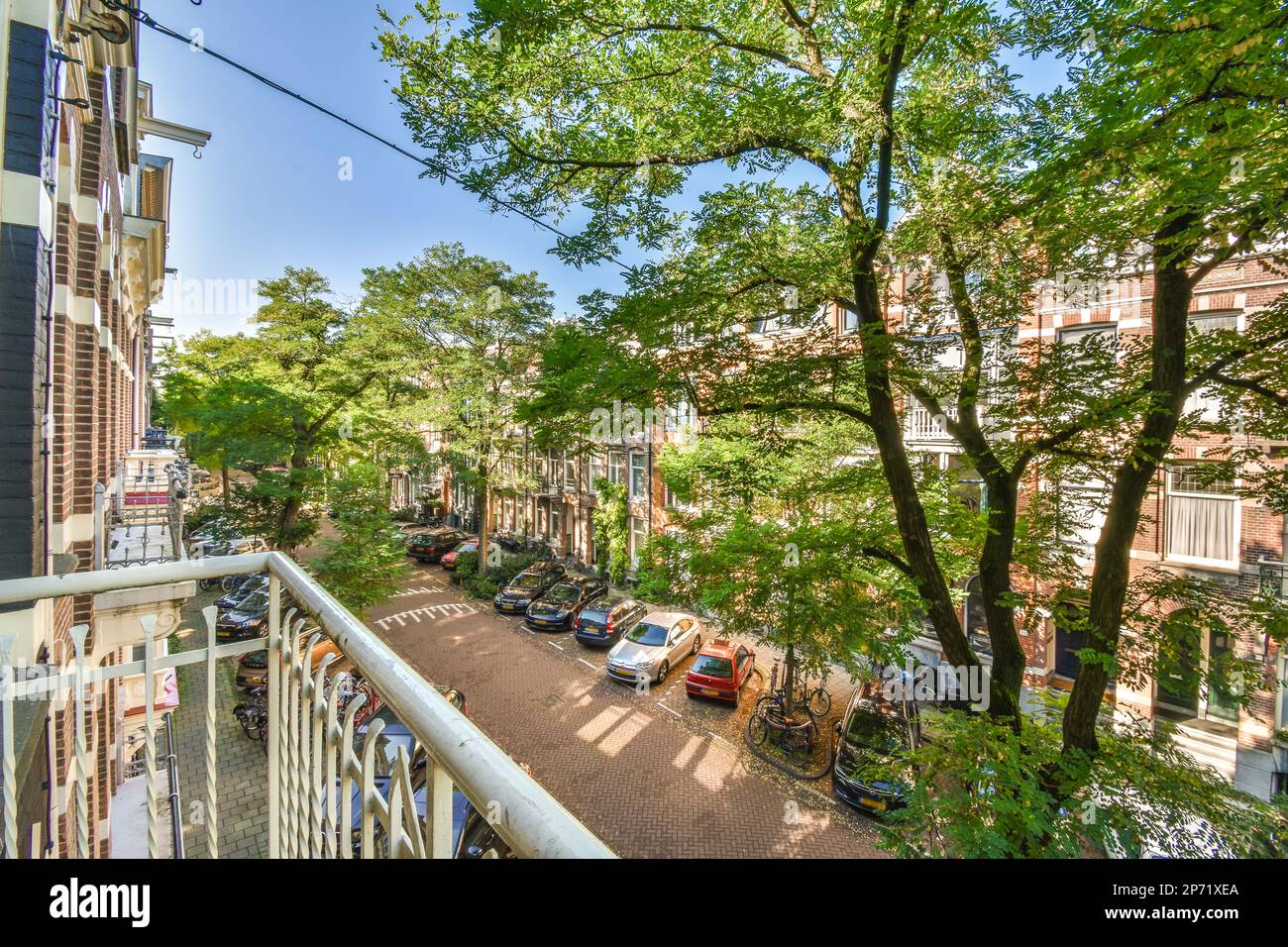 a balcony with cars parked on the street and trees in the background ...