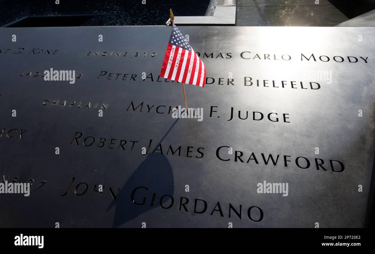 An American flag is stuck into the etched name of Father Mychal F ...