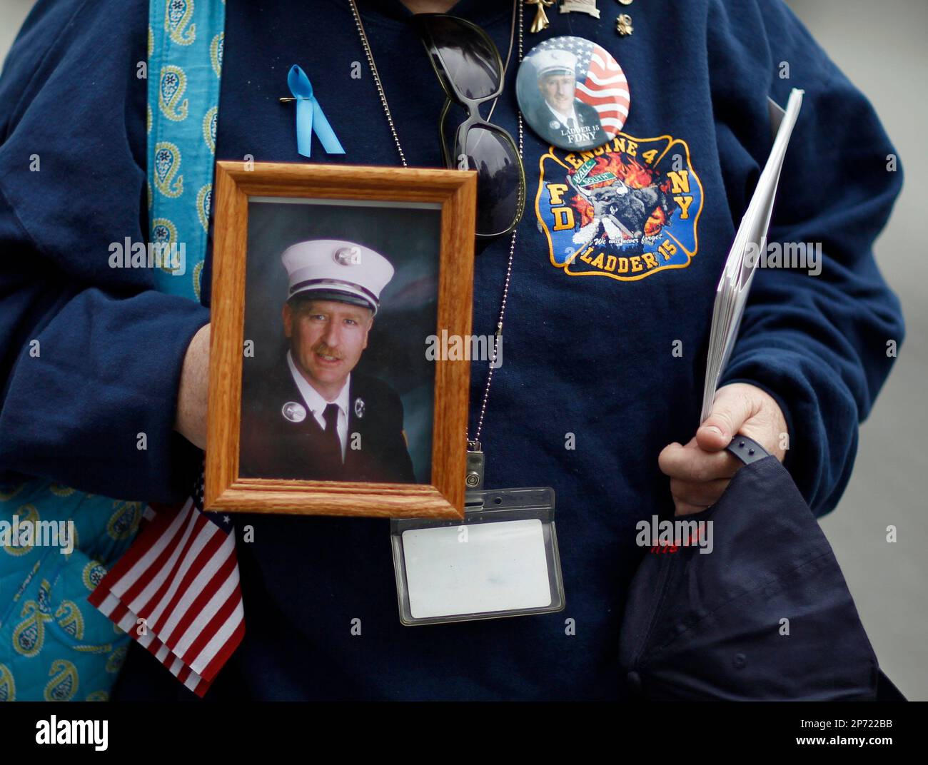 A woman carries a photo of a firefighter at the Sept. 11 memorial ...