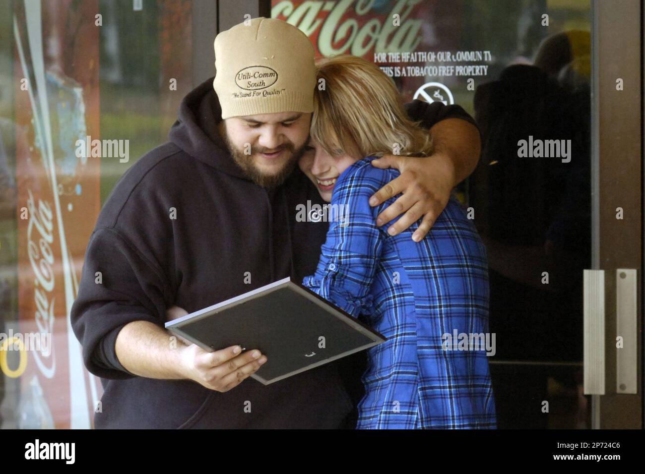 Greg McCrea, 24, receives a certificate of recognition and a hug from ...