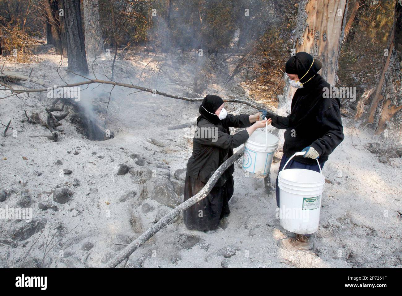 Sister Katerina, right, hands a bucket of water to sister Prodromia ...