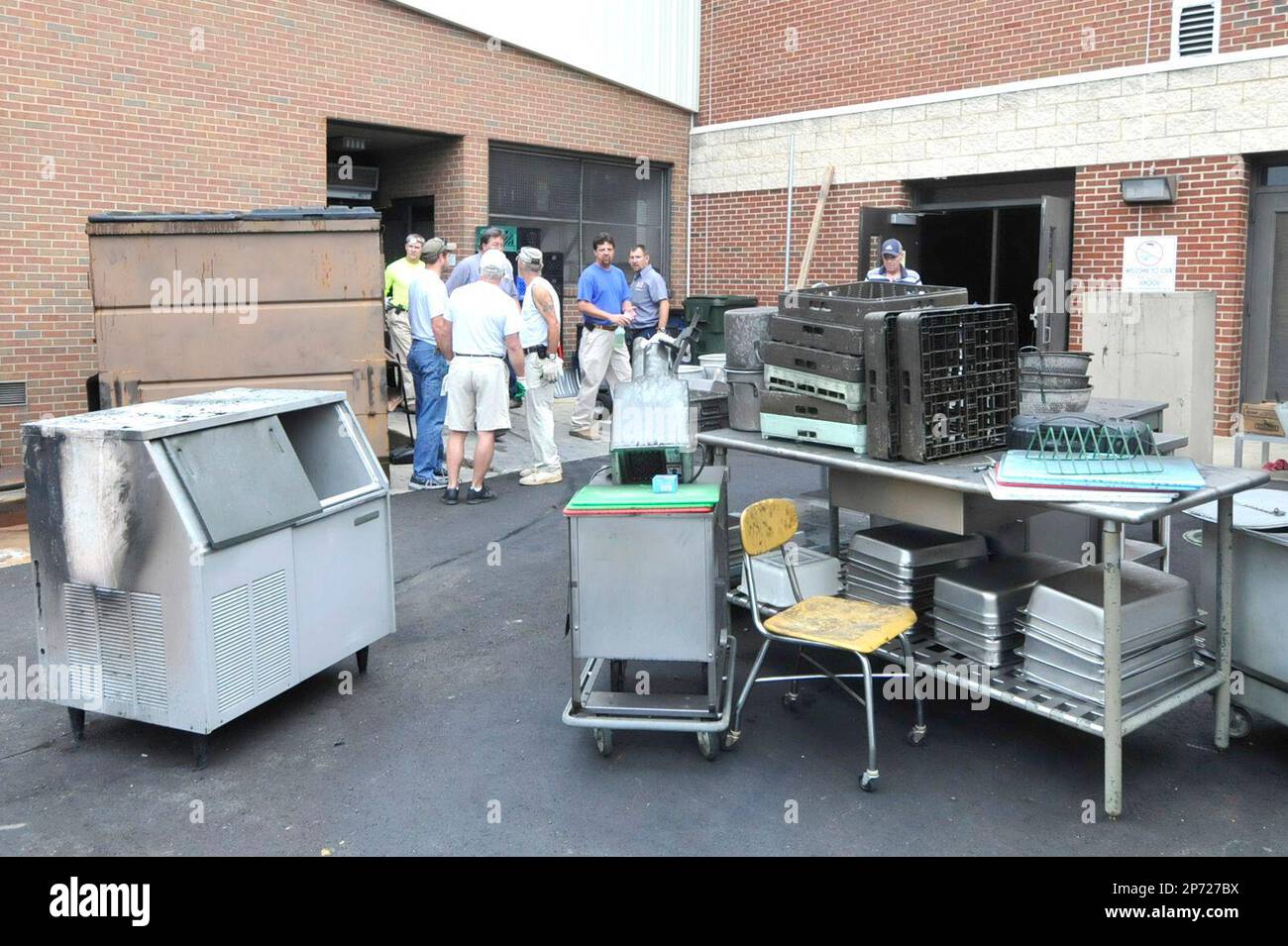 Kitchen equipment is moved outside while workers inside assess damage ...