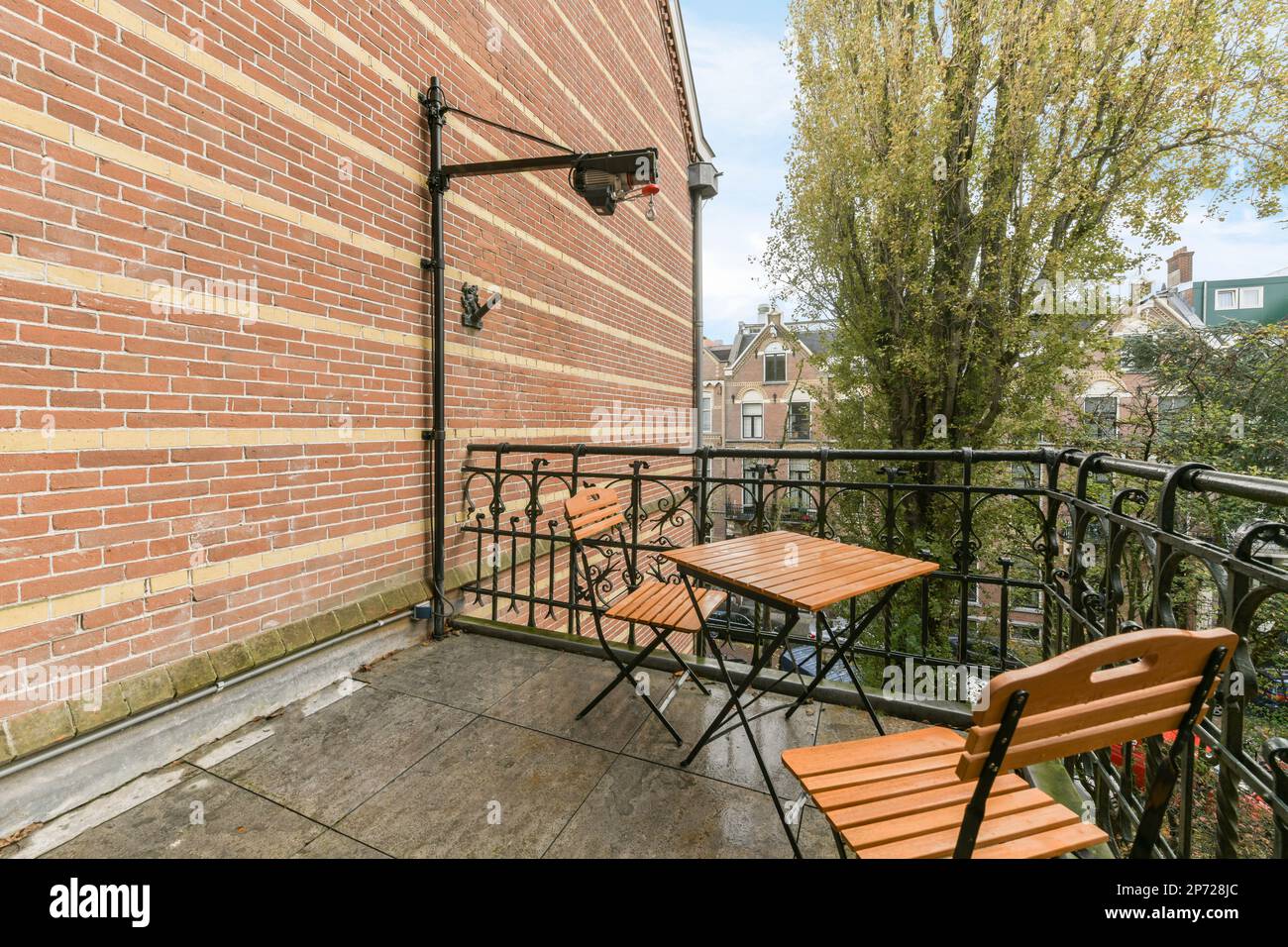 a balcony with two chairs and a table on the left side, looking out to ...