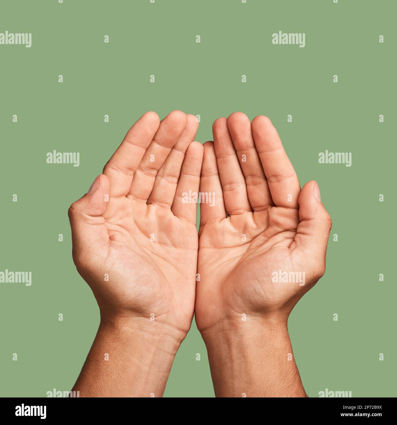 Hands, welfare and poverty with a man in studio on a green background ...