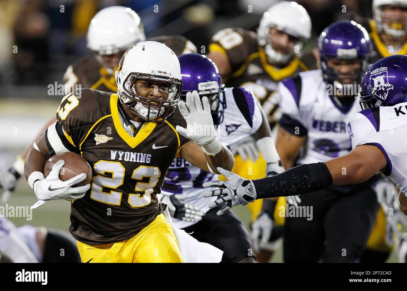 Wyoming running back Ghaali Muhammad (23) side steps a Weber State ...