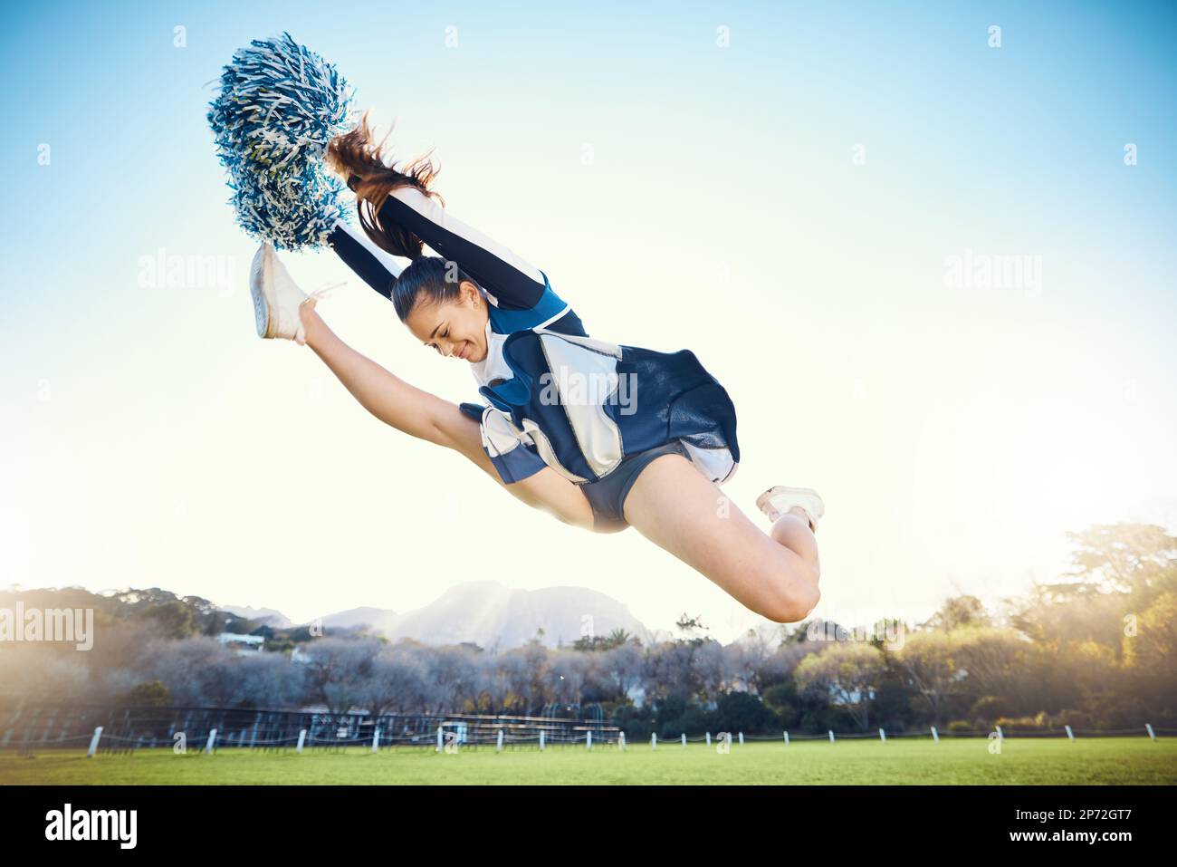 Sports, performance and woman cheerleader jumping while performing a ...