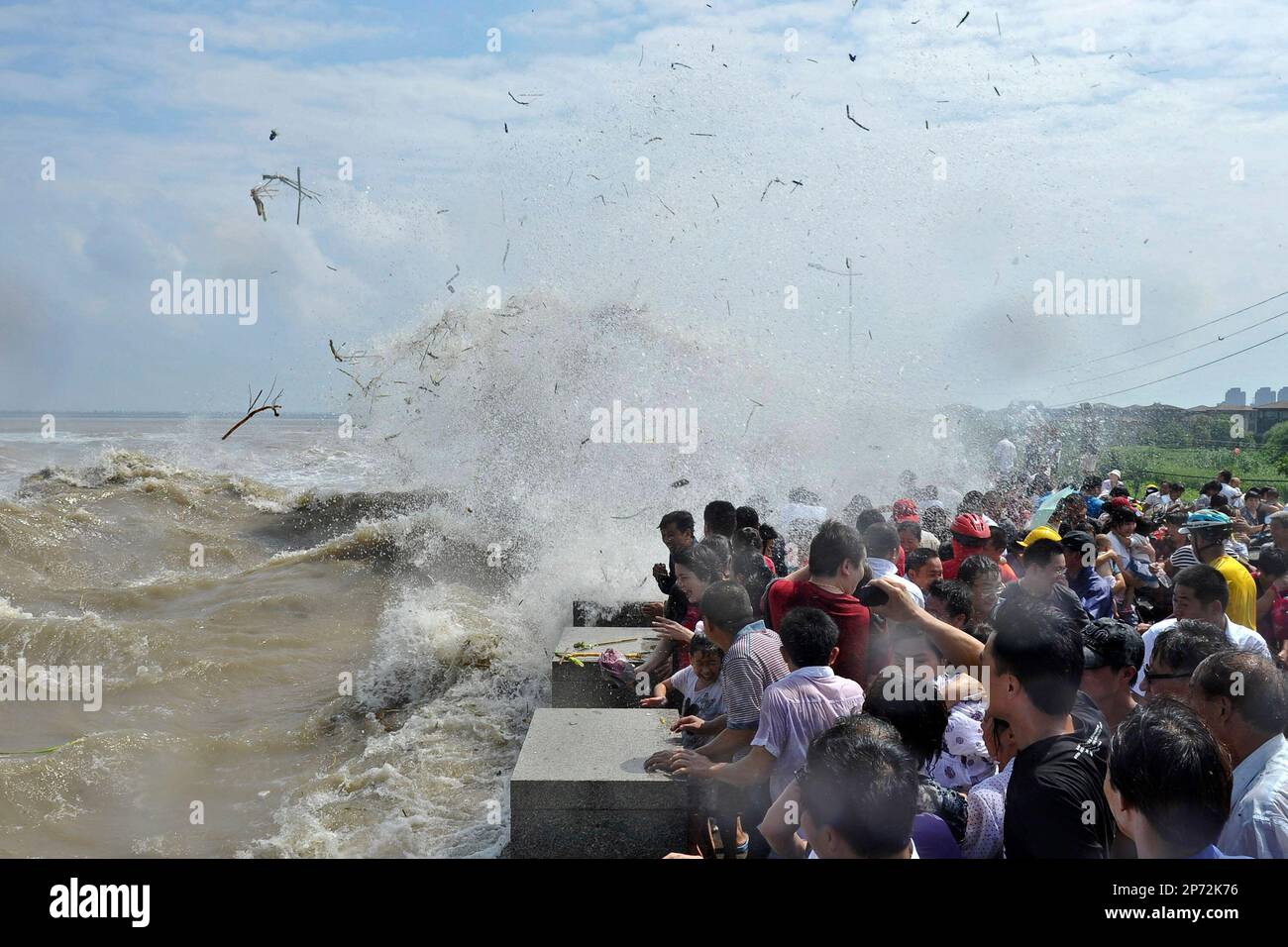 Tourists crowd to see tidal waves hitting the bank of Qiantang River ...