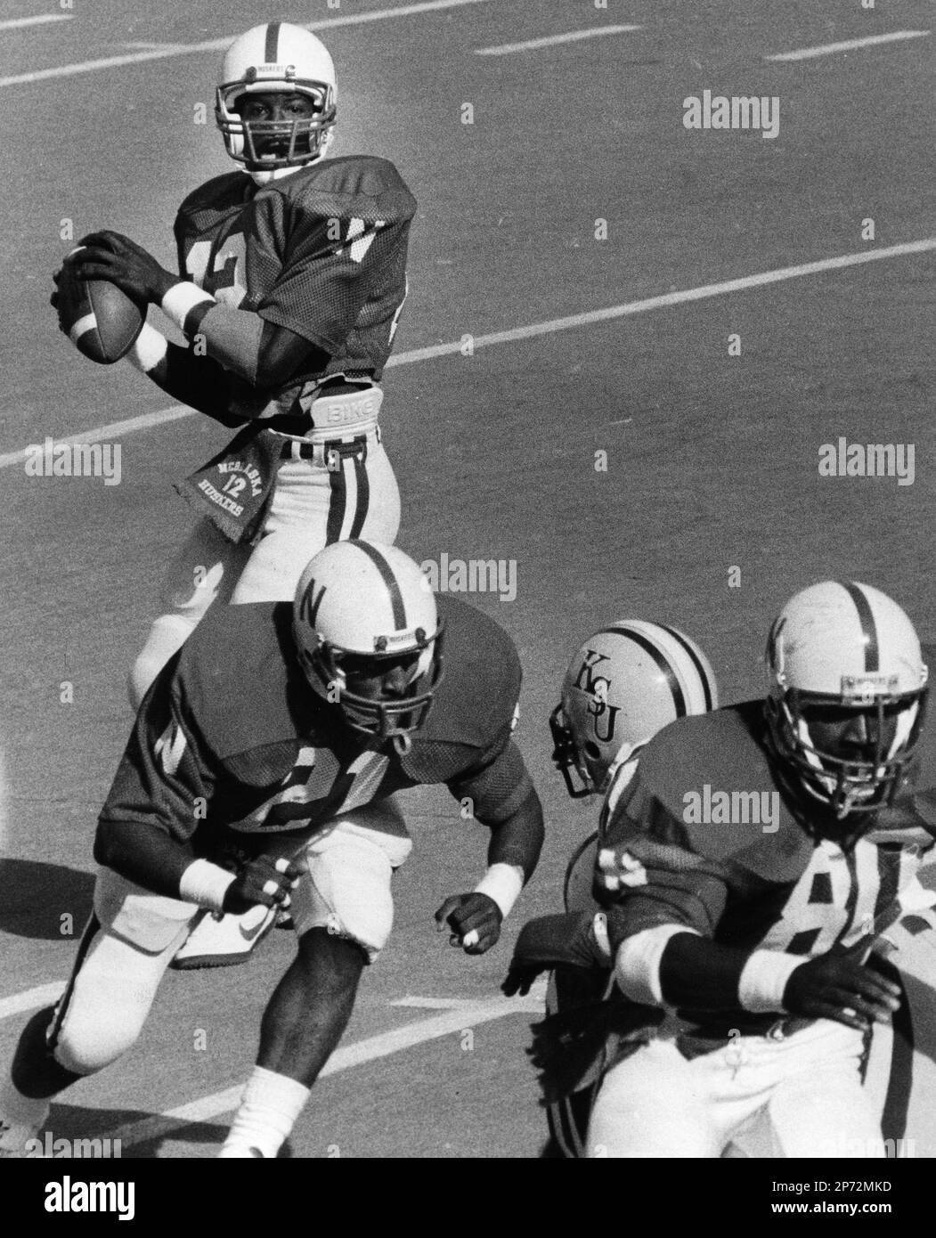 Passing or running, the Huskers' quarterback Turner Gill moves as the ...