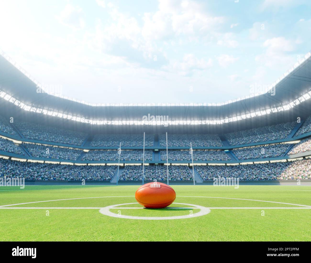 A red aussie rules ball on the center line of a stadium with posts on a ...