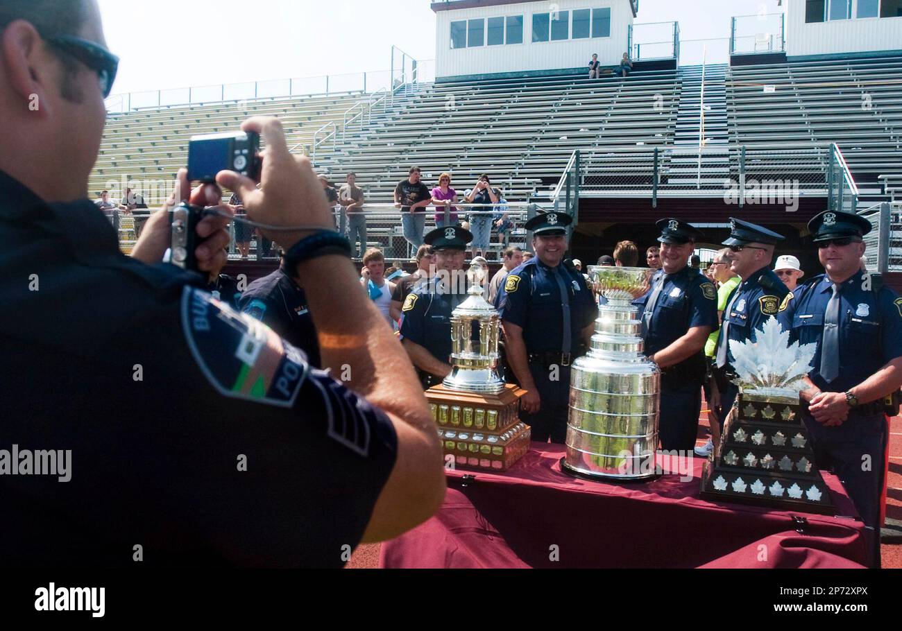 Michigan State Police officers pose with the Stanley Cup and Tim Thomas ...