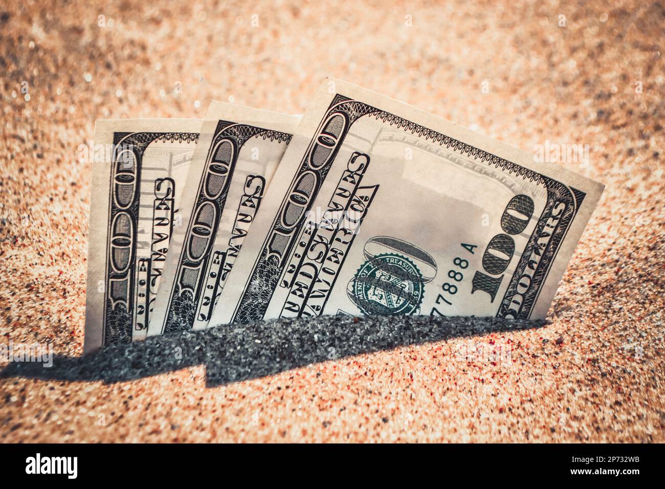 Money dolars half covered with sand lie on beach close-up. Money grows ...