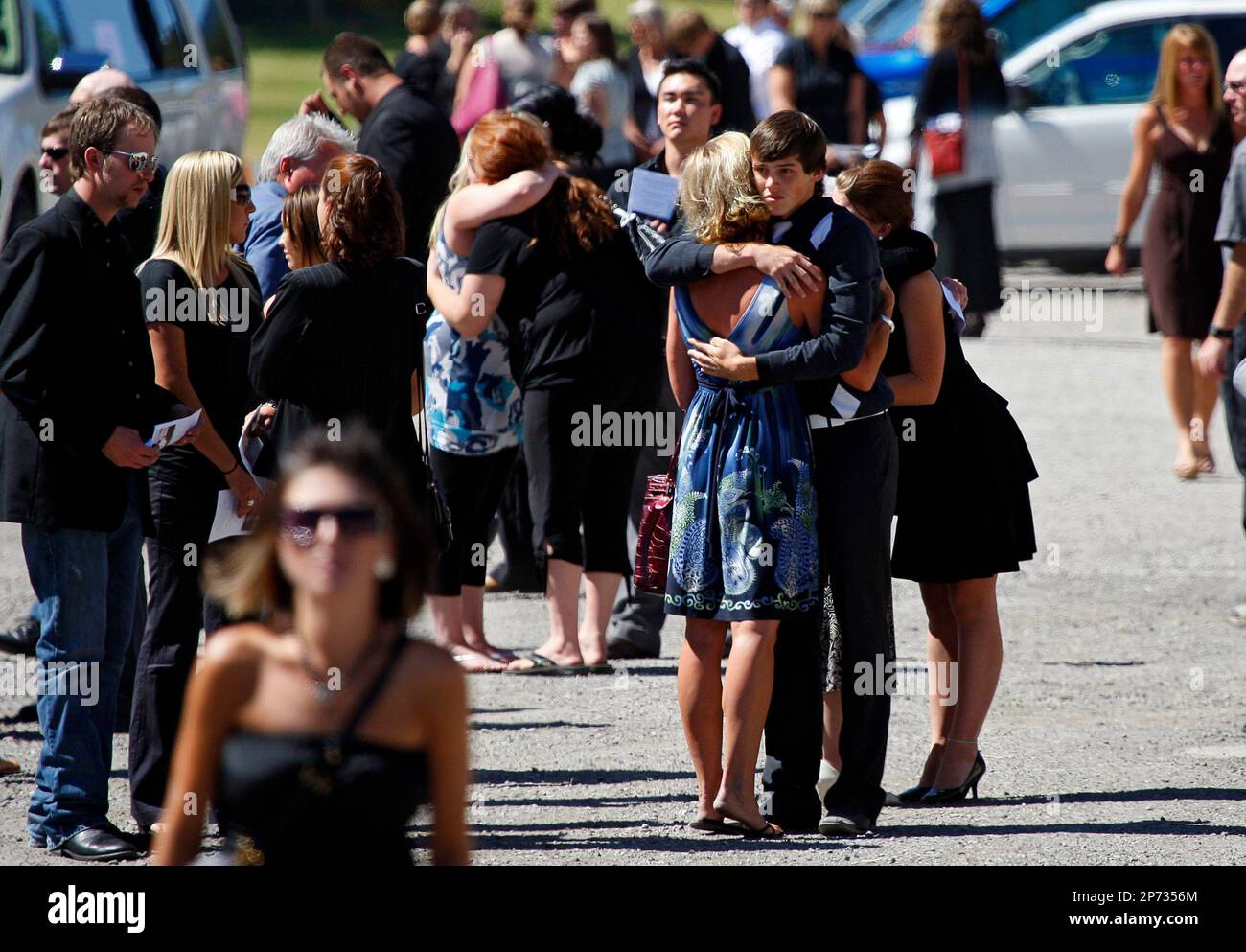 Mourners comfort each other following the funeral service for NHL ...