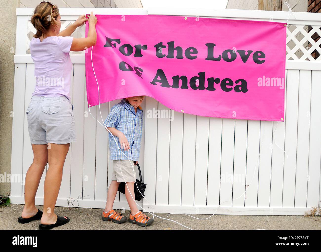 Amy Howard puts up a sign for her cousin Andrea Vellinga, while her son ...