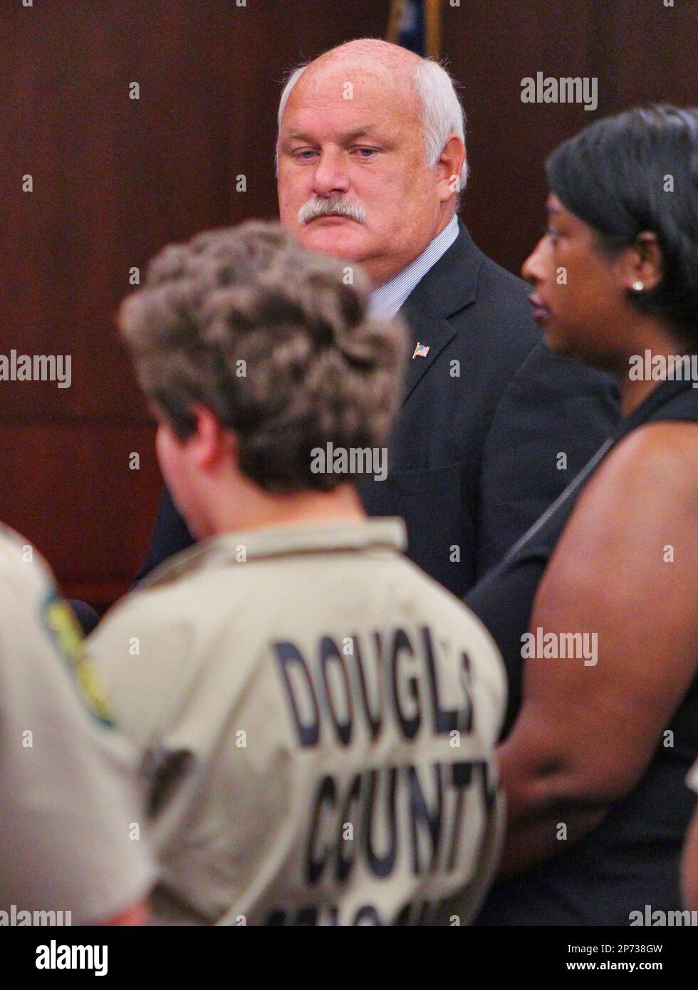 Douglas County District Attorney David McDade, center rear, stares at ...