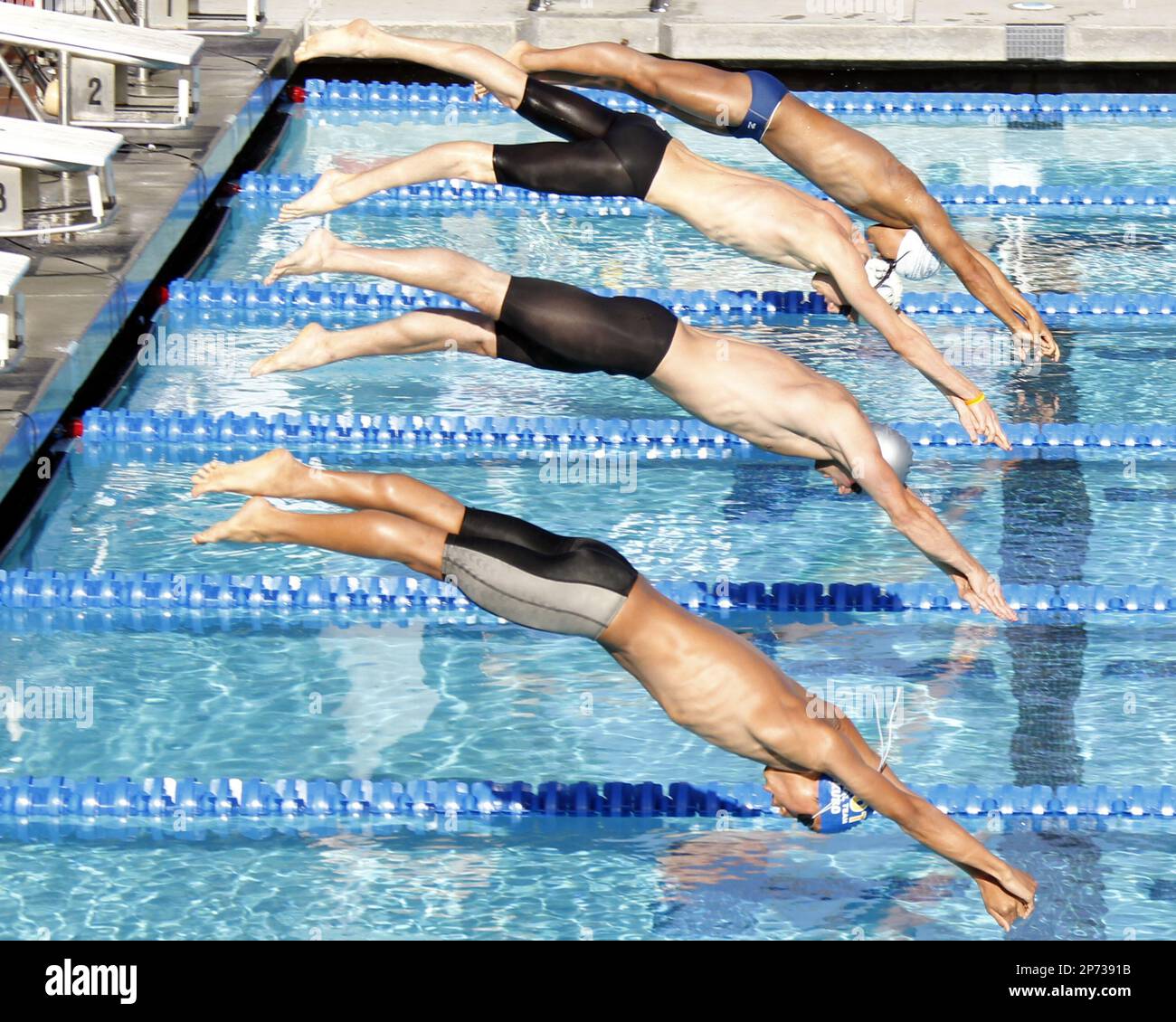 Competitors dive into the water for the start of the mens 200 meter ...