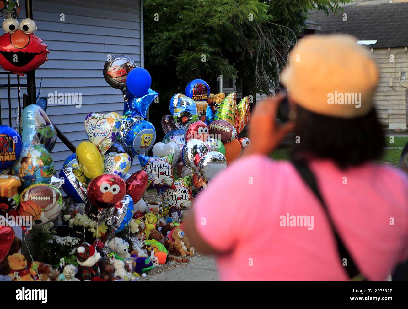 A memorial made up of balloons, teddy bears, flowers, and personal ...