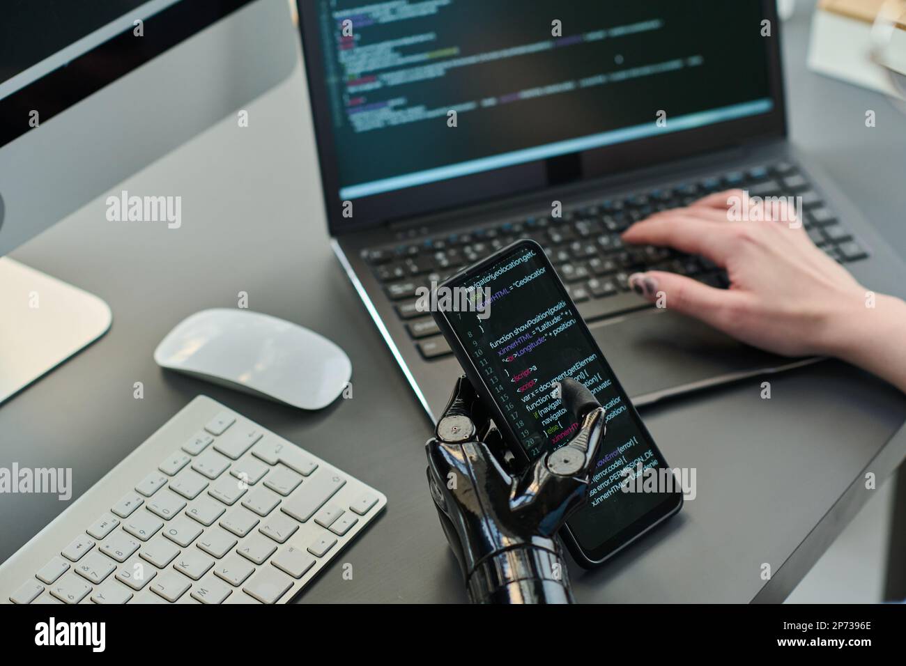 Close-up of developer typing security codes on smartphone and laptop for new computer program ...