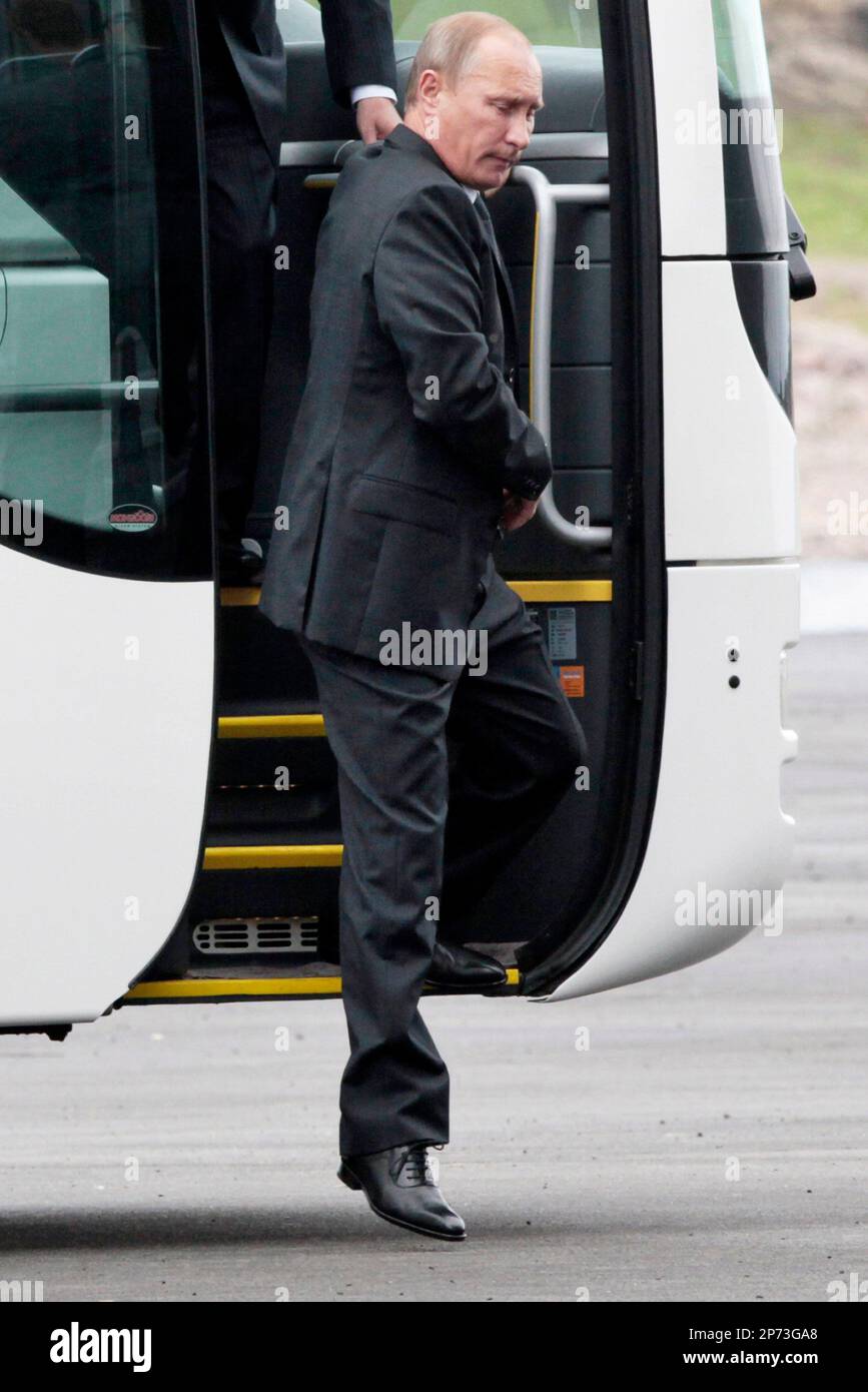 Russian Prime Minister Vladimir Putin steps down from a bus as he ...