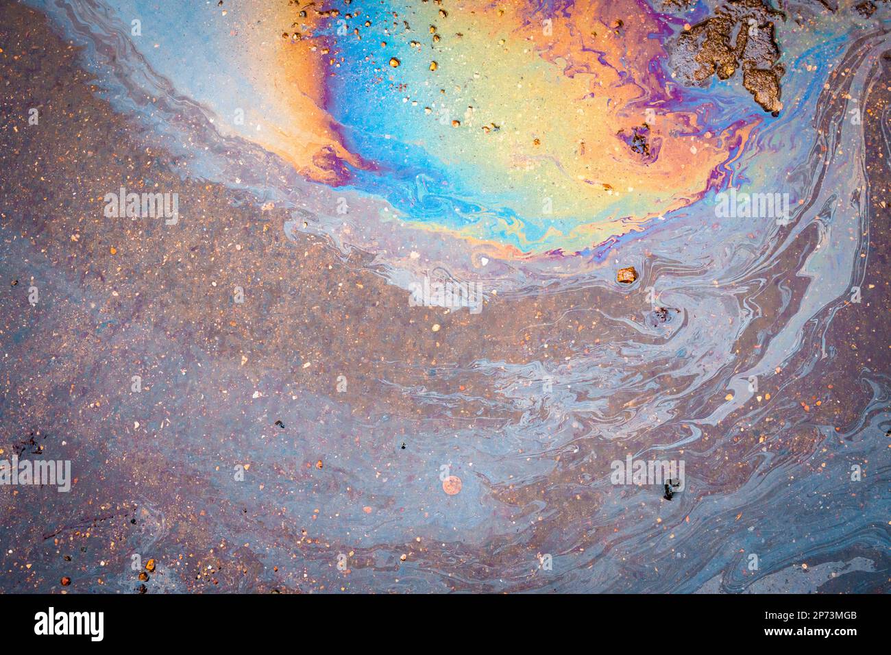rainbow spots from spilled engine oil in puddle Stock Photo - Alamy