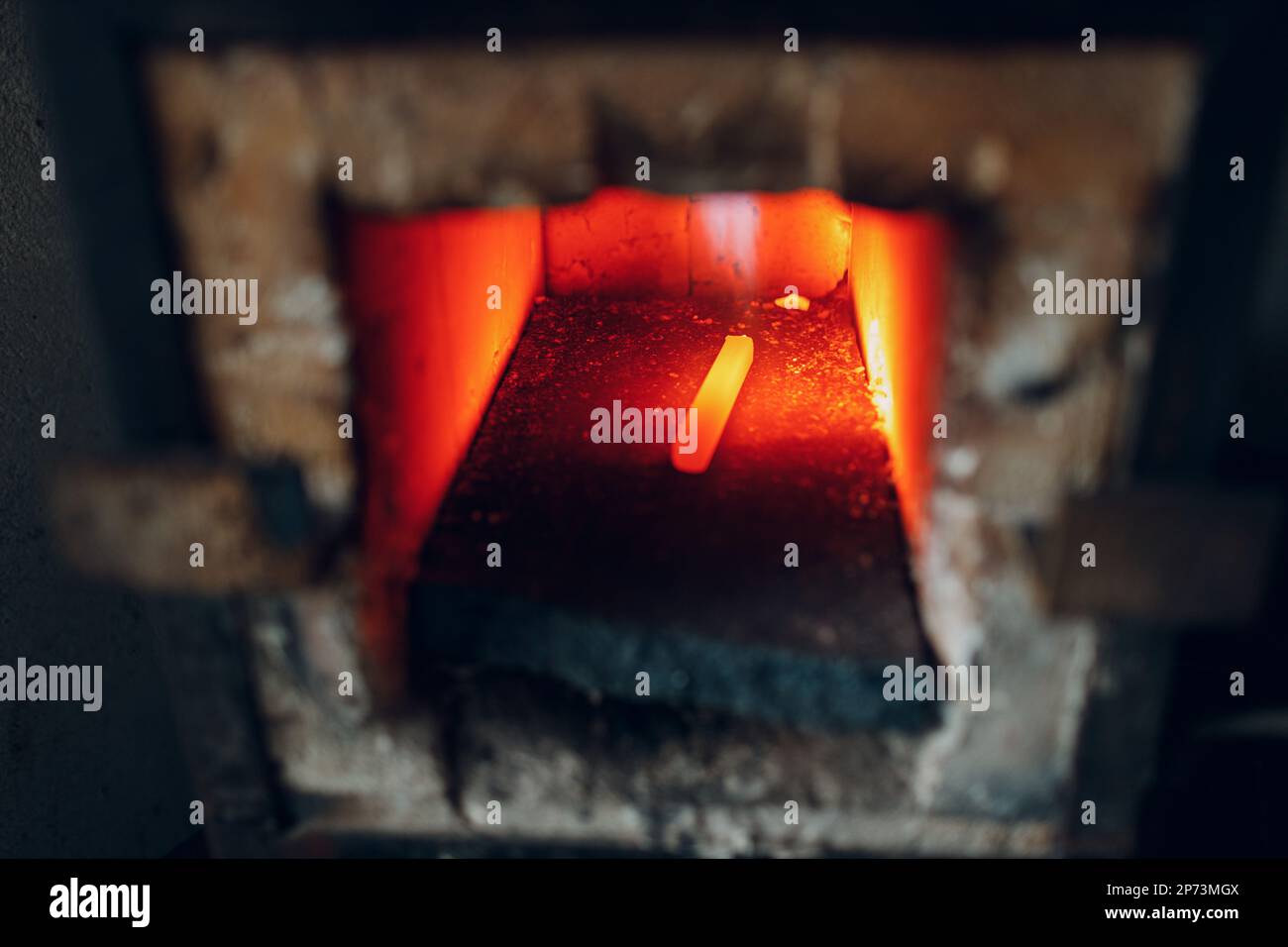 Blacksmith forge oven with hot flame. Smith heating iron piece of steel ...