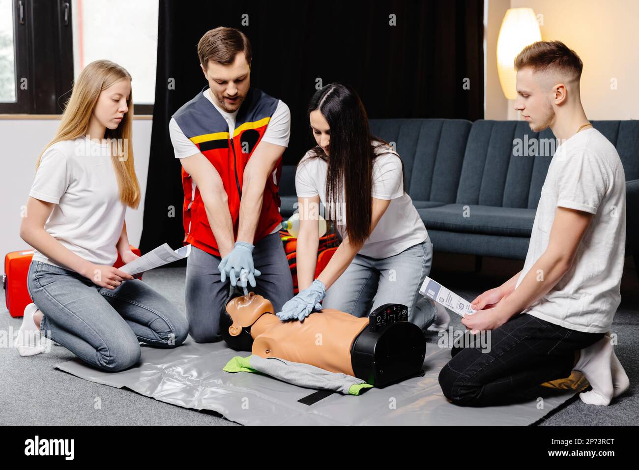 Group of people learning how to make first aid heart compressions with ...