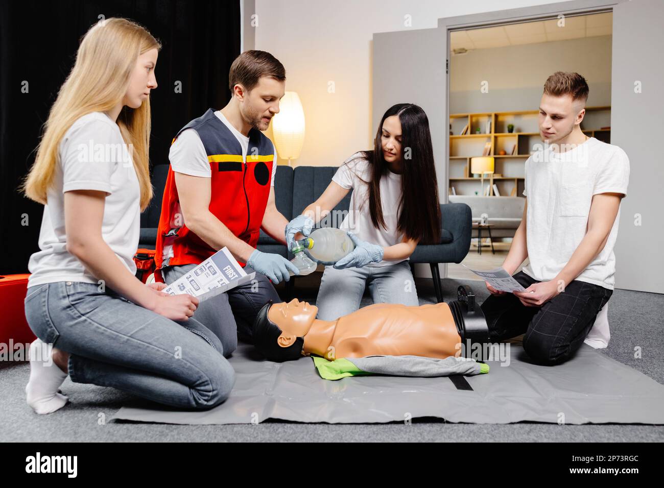 Group of people learning how to make first aid heart compressions with ...