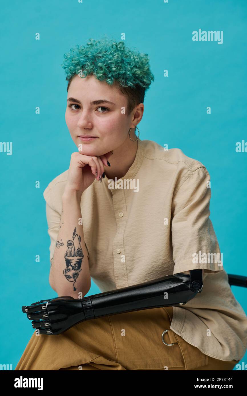 Portrait of young girl with prosthetic arm looking at camera isolated ...