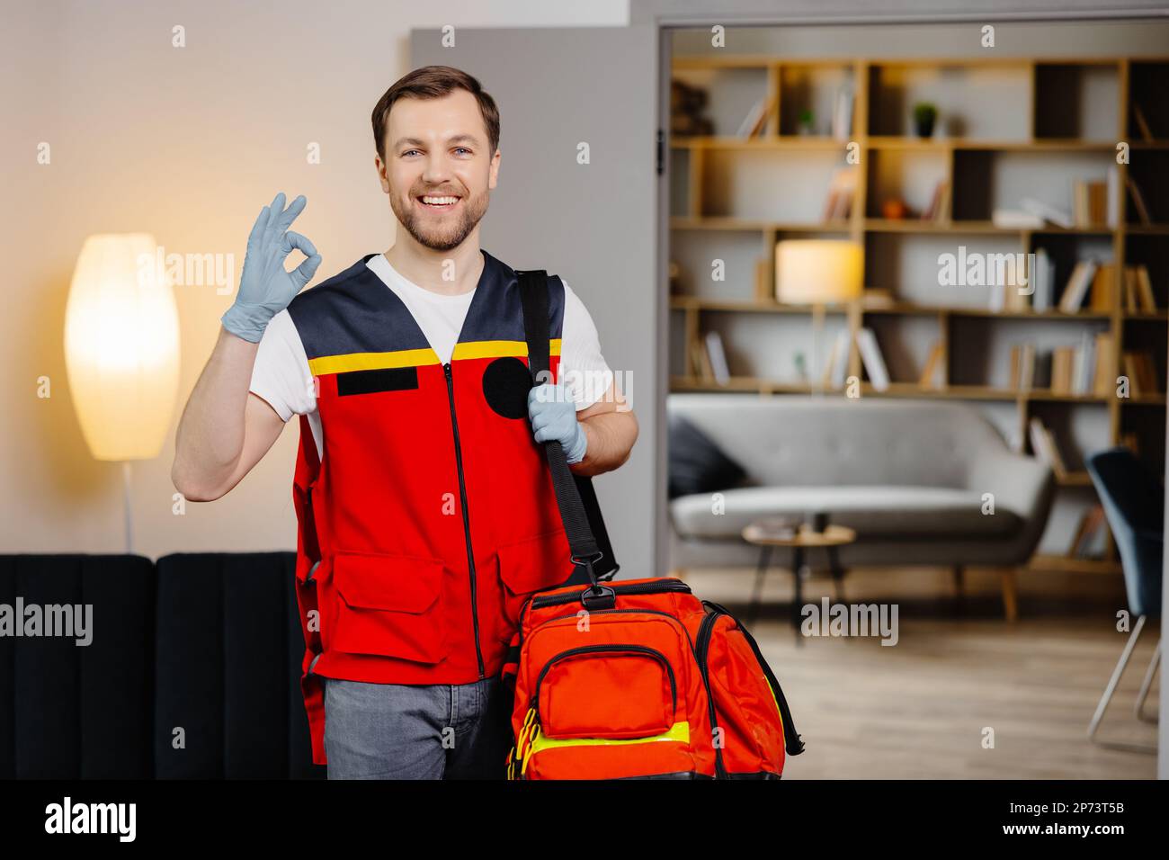 First aid course. A young male paramedic with a bag on his shoulders is ...