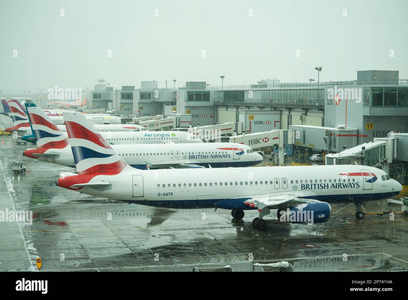 London, UK. 8 March 2023. Commercial airlines at the gates during heavy ...