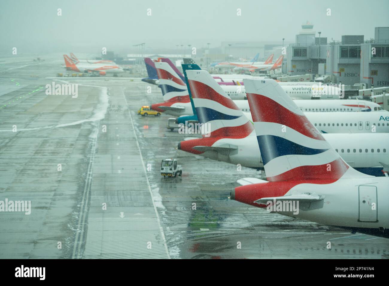 London, UK. 8 March 2023. Commercial airlines at the gates during heavy ...