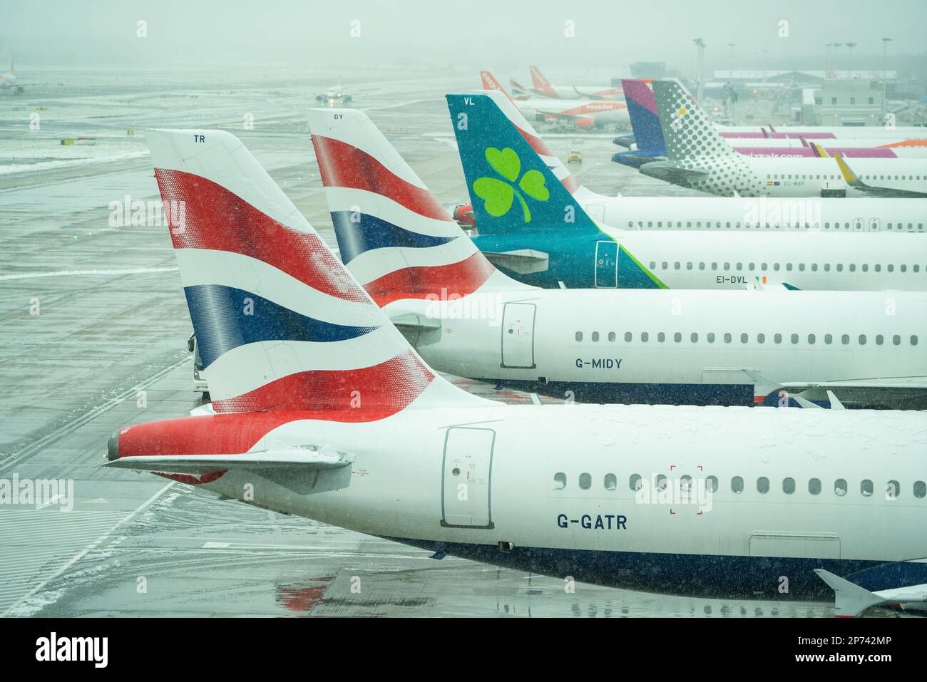 London, UK. 8 March 2023. Commercial airlines at the gates during heavy ...