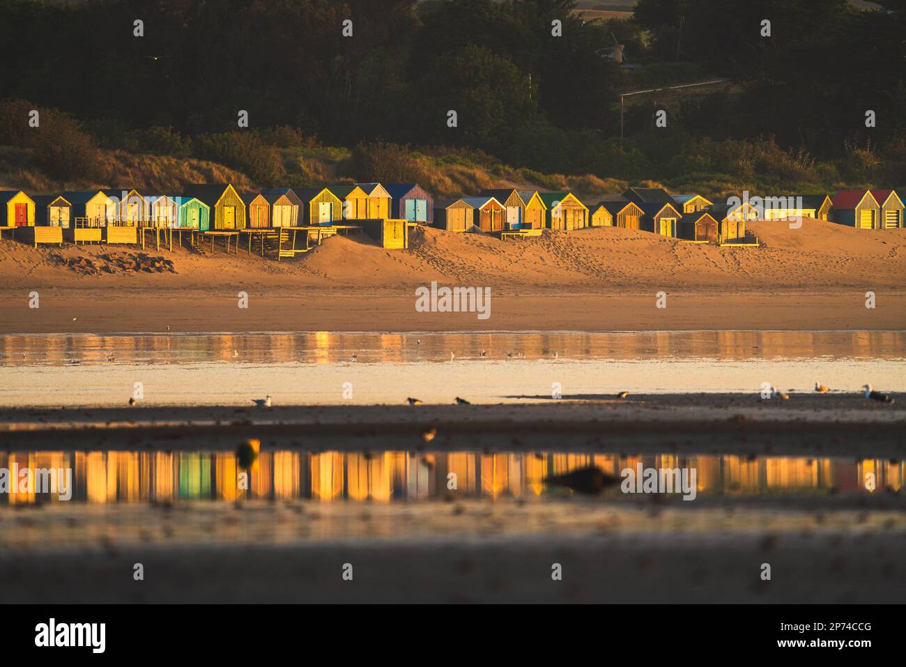 Reflection of beach huts in Abersoch glowing in the sunrise Stock Photo ...