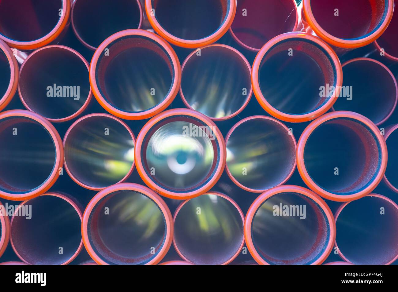 Large pile of orange plastic PVC pipes Stock Photo - Alamy