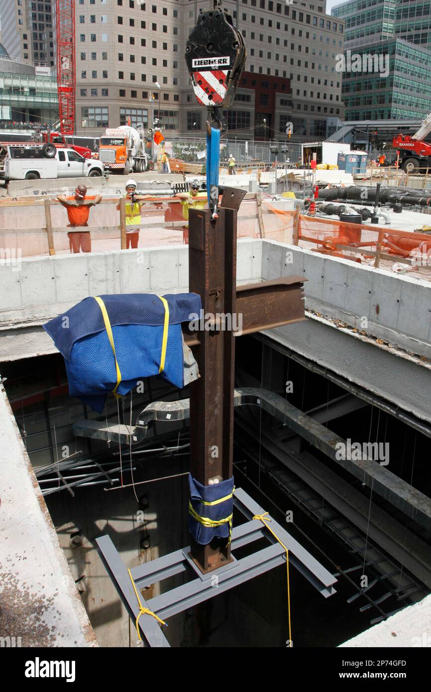 The September 11 cross is lowered by crane into a subterranean section ...