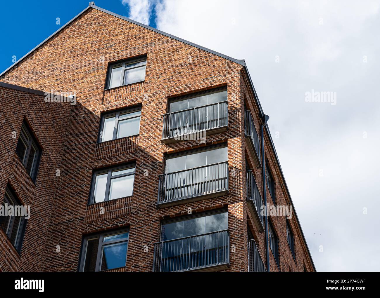 Looking up a tall newly constructed brick apartment building Stock ...