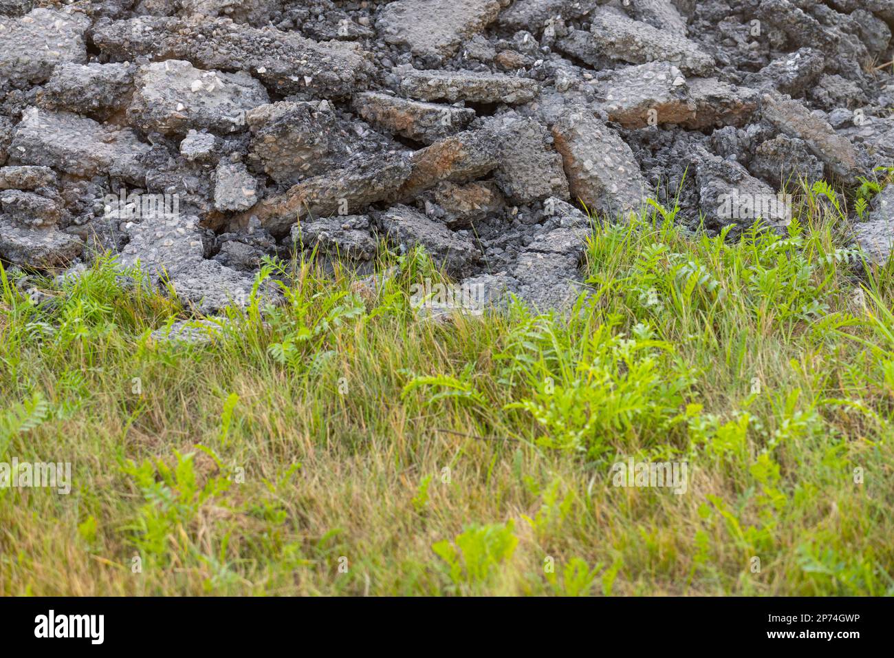 Chunks of old asphalt dumped in a grass field Stock Photo - Alamy