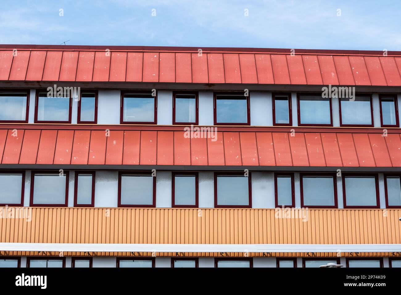 Facade of a red white and orange office building Stock Photo - Alamy