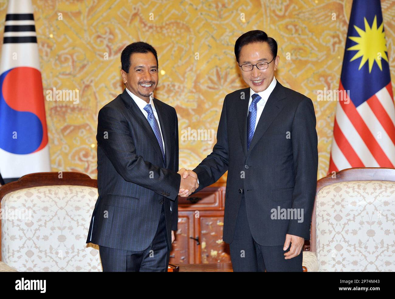 South Korean President Lee Myung-bak, right, shakes hands with ...