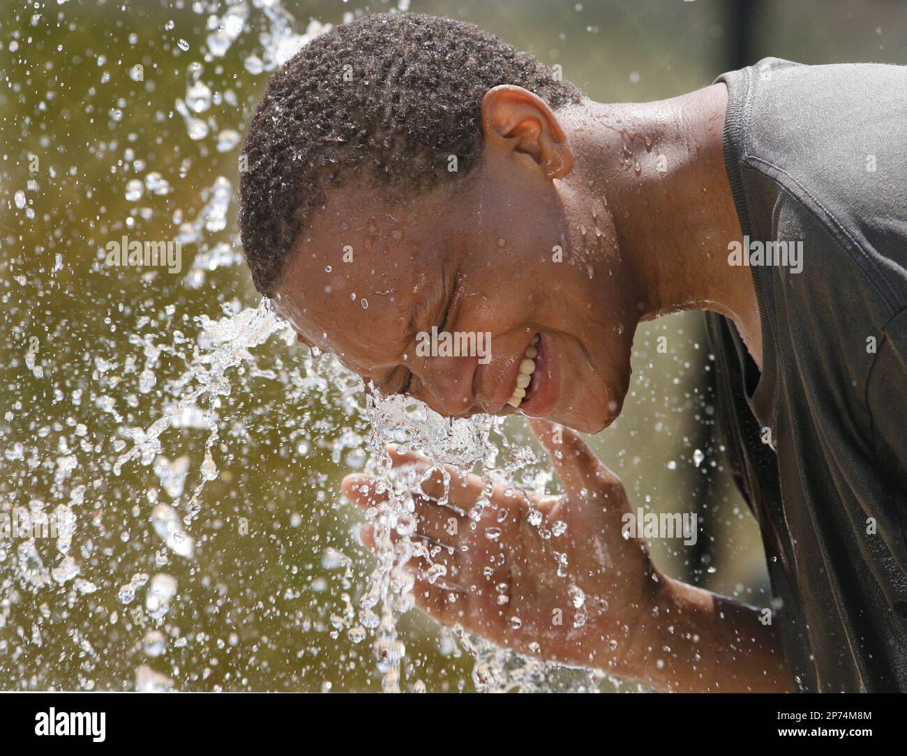 Karen Tyson, of Grand Rapids, finds relief from the heat in a fountain ...