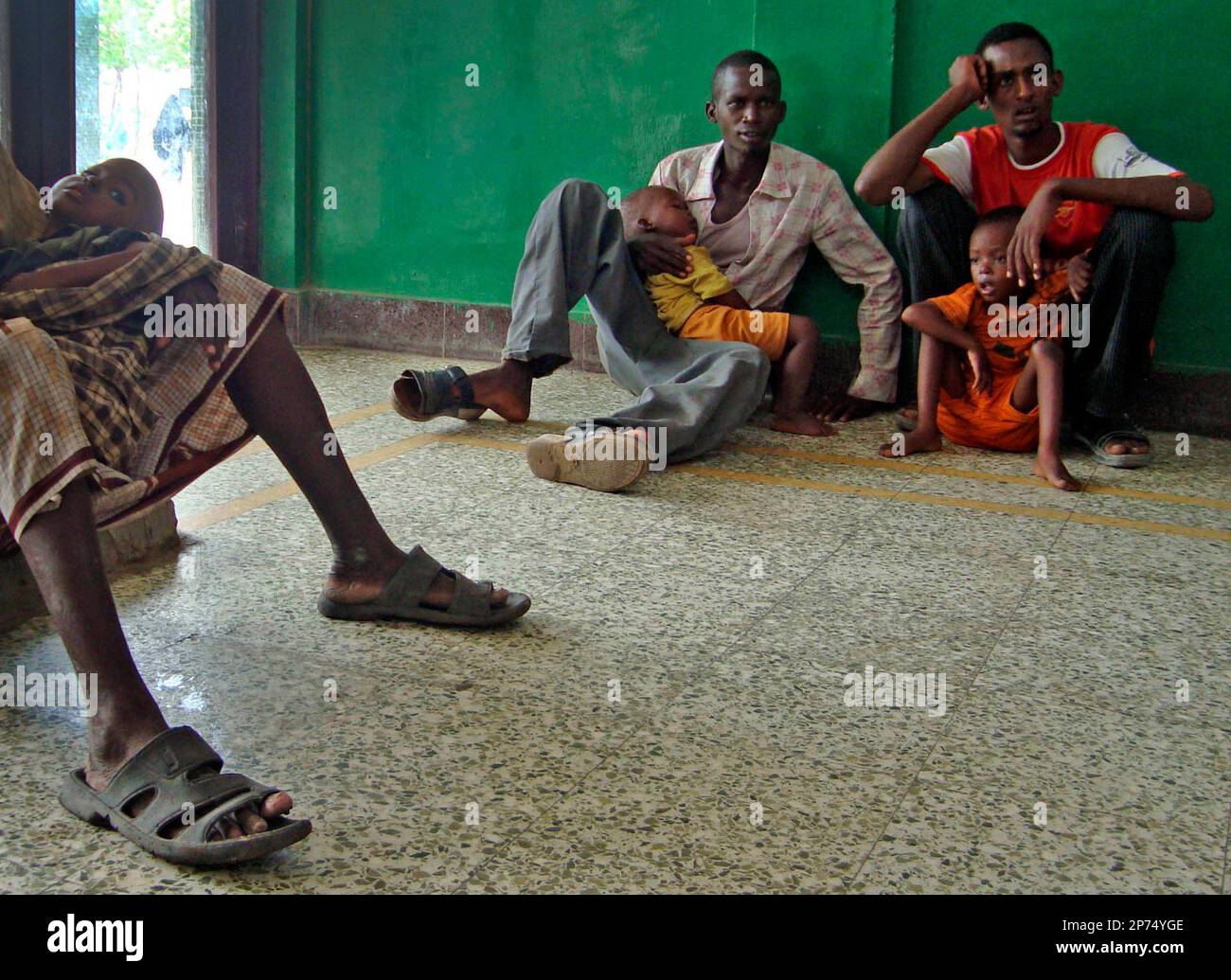 Fathers from southern Somalia hold their malnourished children at ...