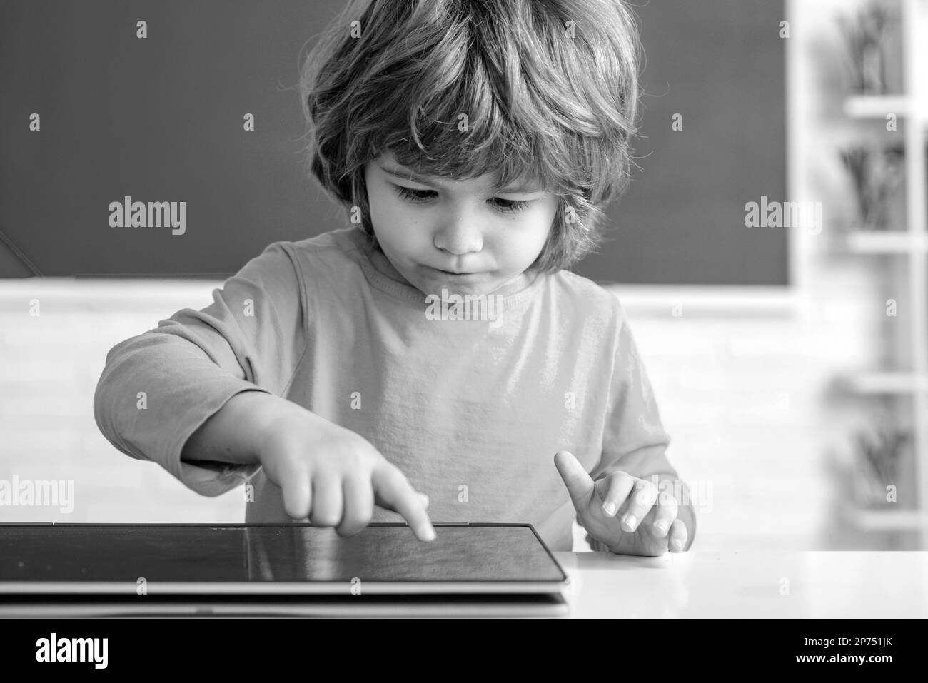School child with tablet in school classroom. Pupil in class using ...