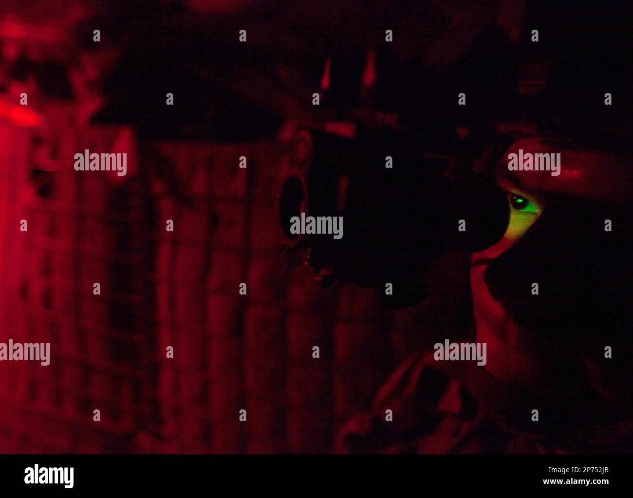 The glow of night vision goggles is seen on the face of Sgt. Jesse ...