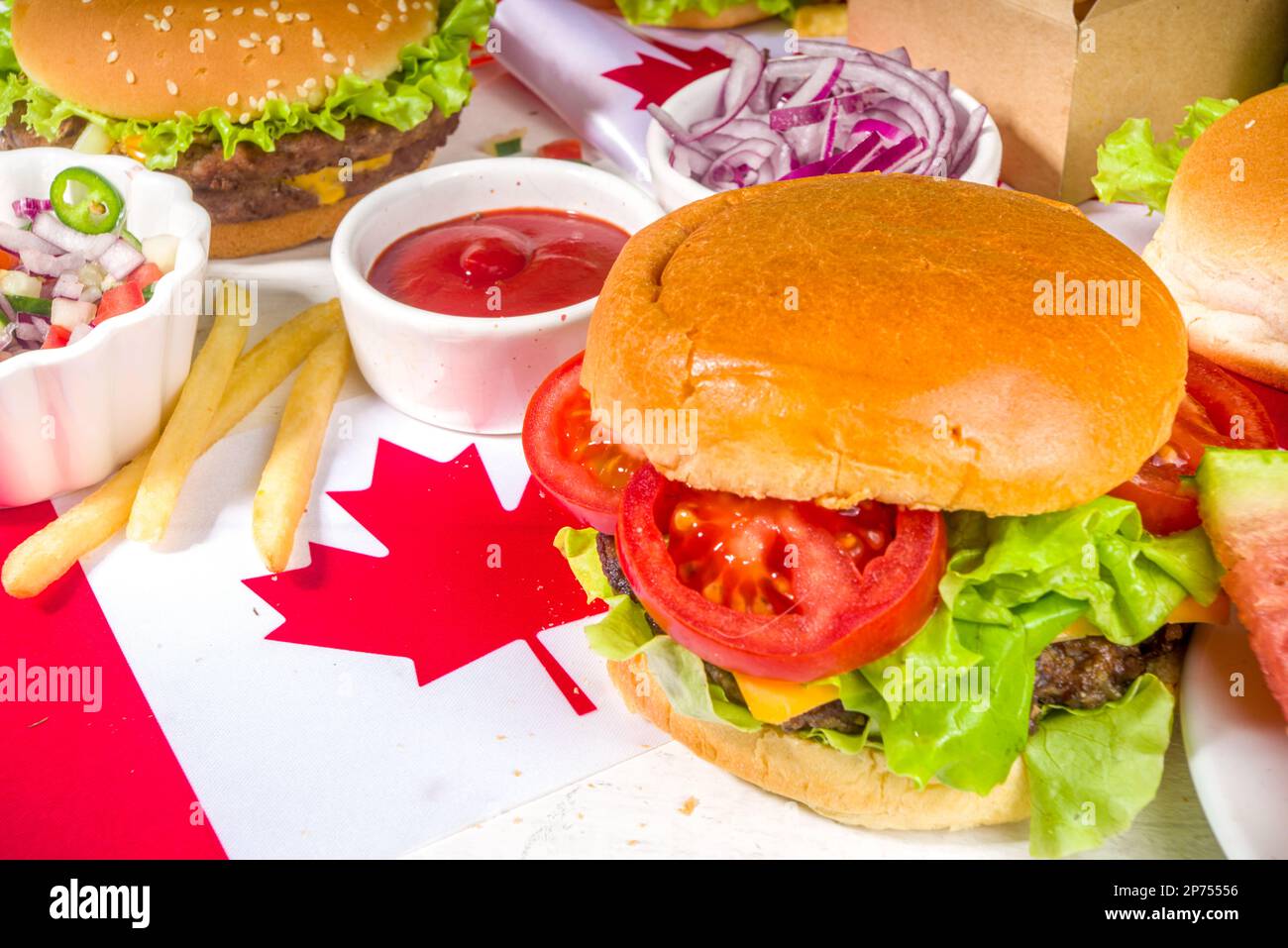 Set of various Canada Day bbq food. Picnic party table with maple leaf shaped watermelon, flags ...