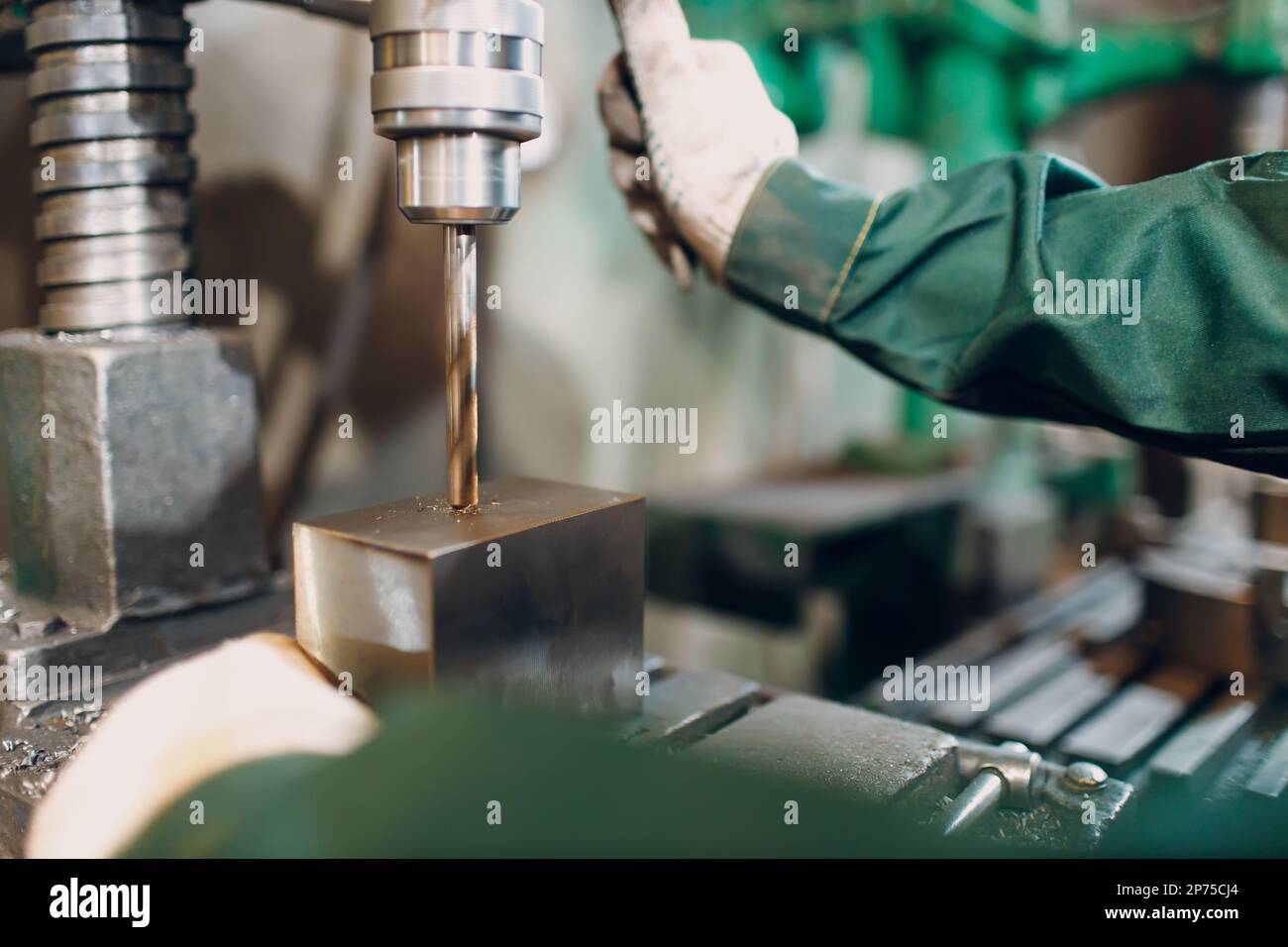 Worker with drilling boring machine works on metal factory Stock Photo ...
