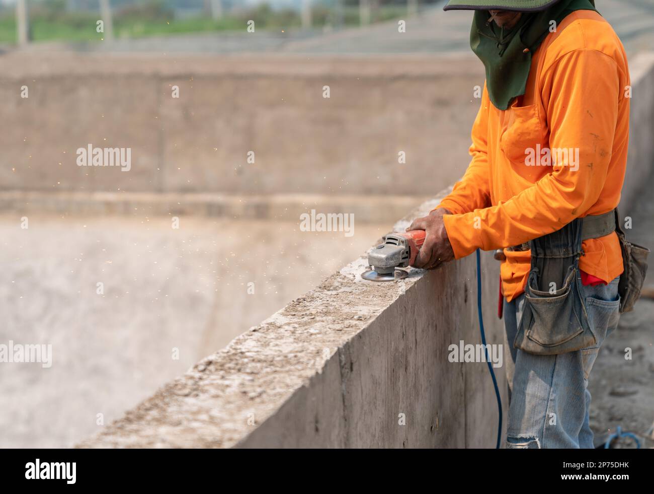 Worker cutting steel bar with an angle grinder in construction site ...