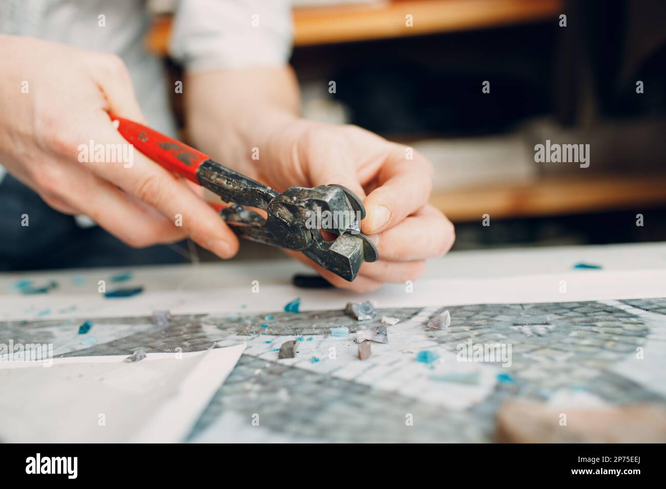 Craftsman cutting smalt glass with nippers cutters for making smalt ...
