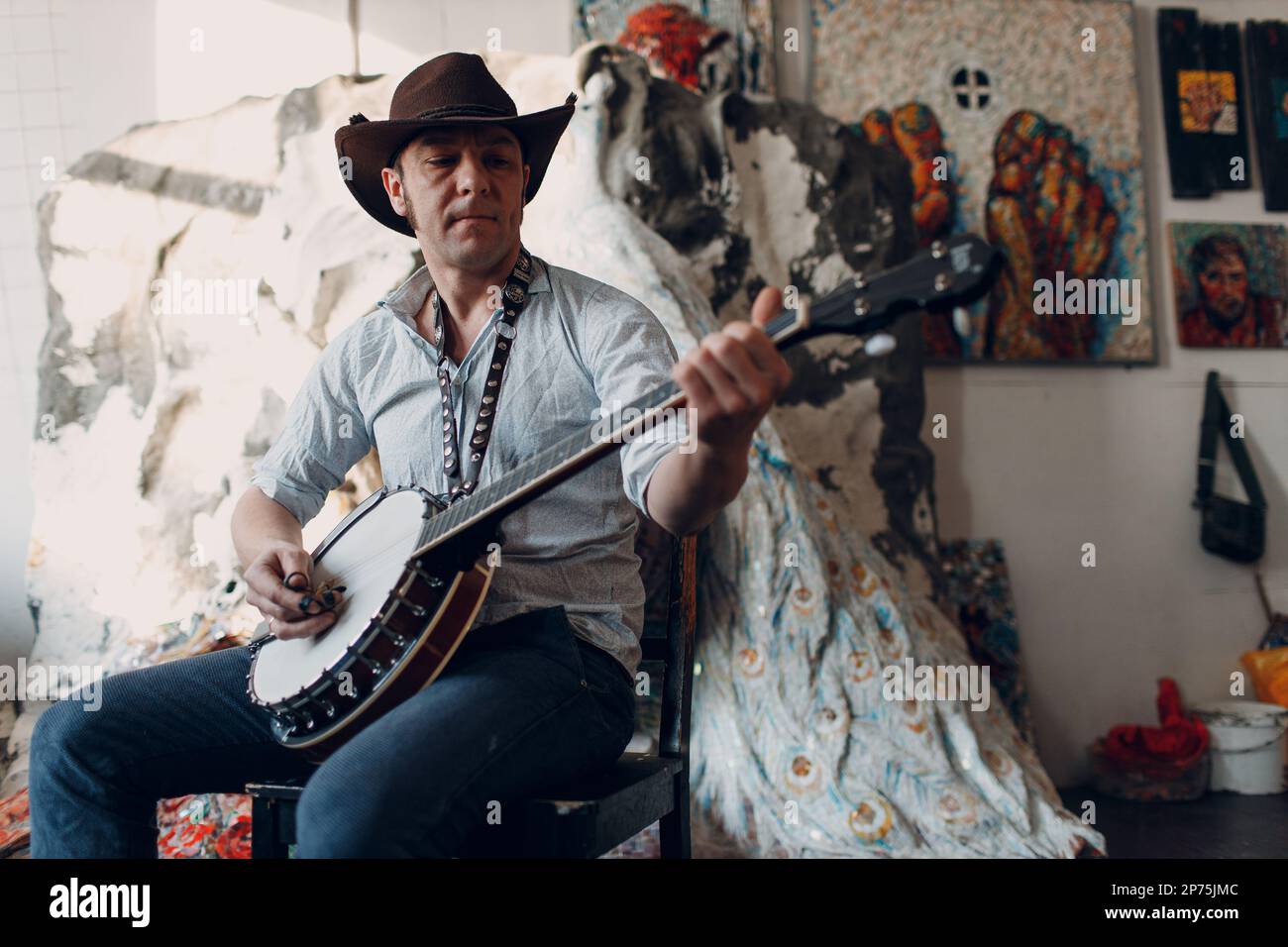 Male musician playing banjo sitting chair indoor Stock Photo - Alamy
