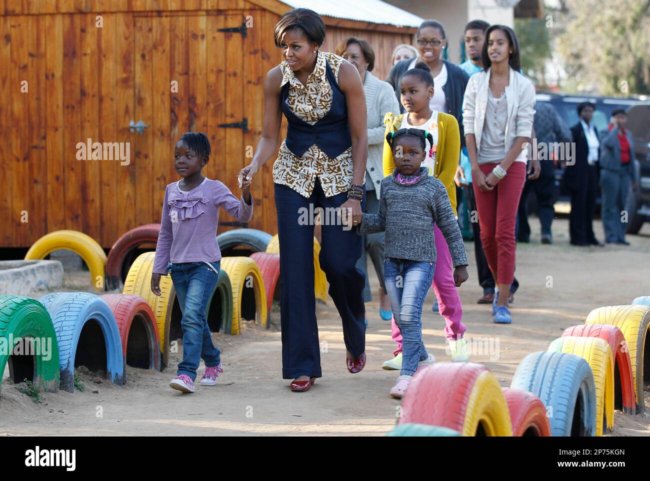 First lady Michelle Obama walks with children as she visits the ...
