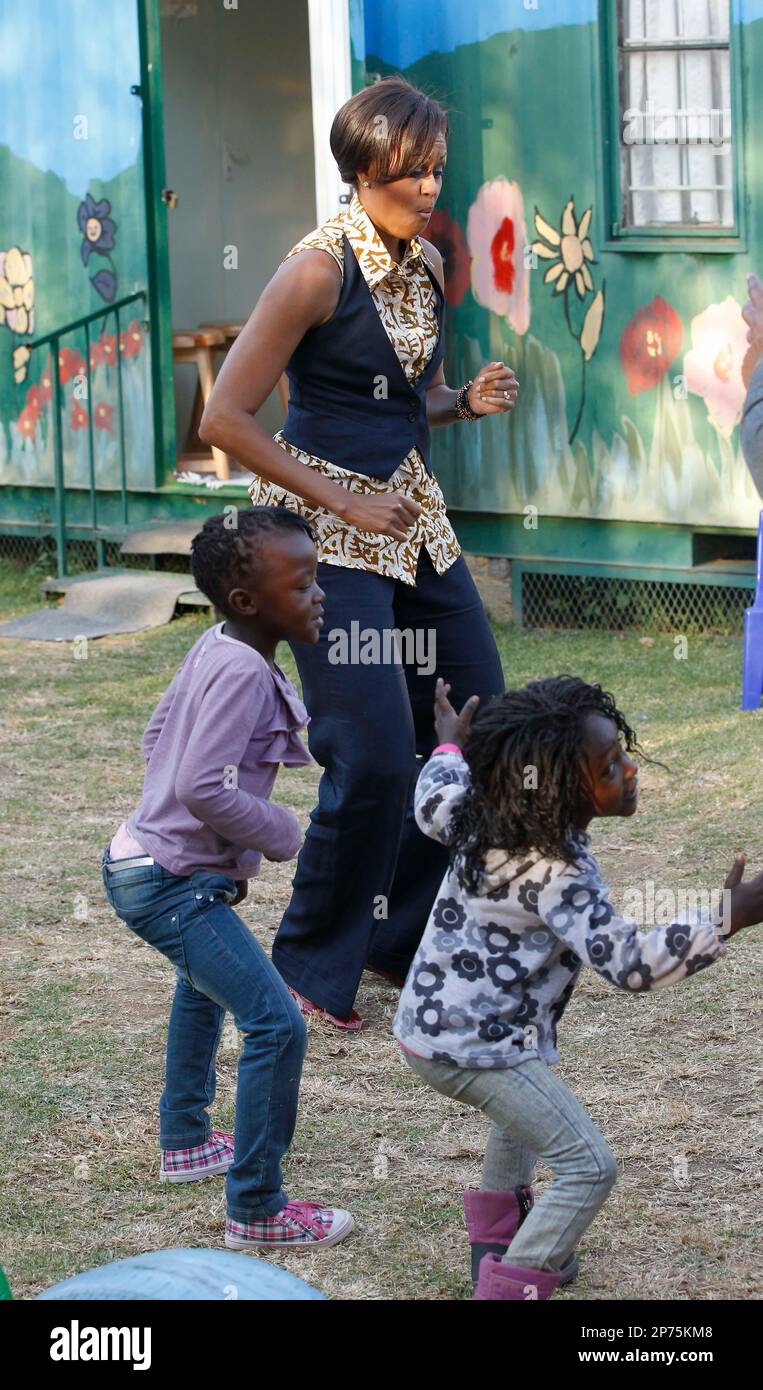 First lady Michelle Obama dances with children as she visits the ...