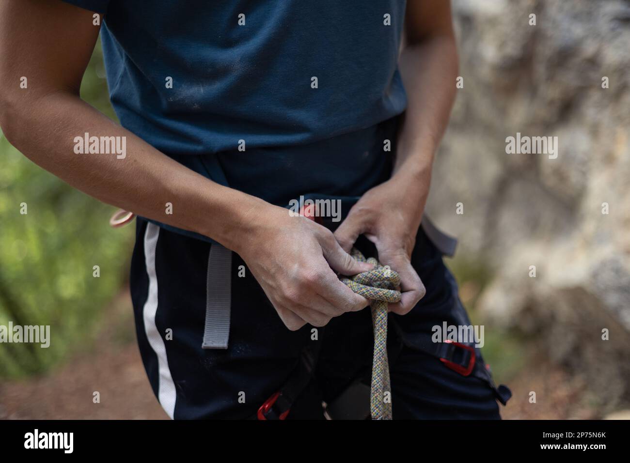 MCU Male climber tying a knot Stock Photo - Alamy